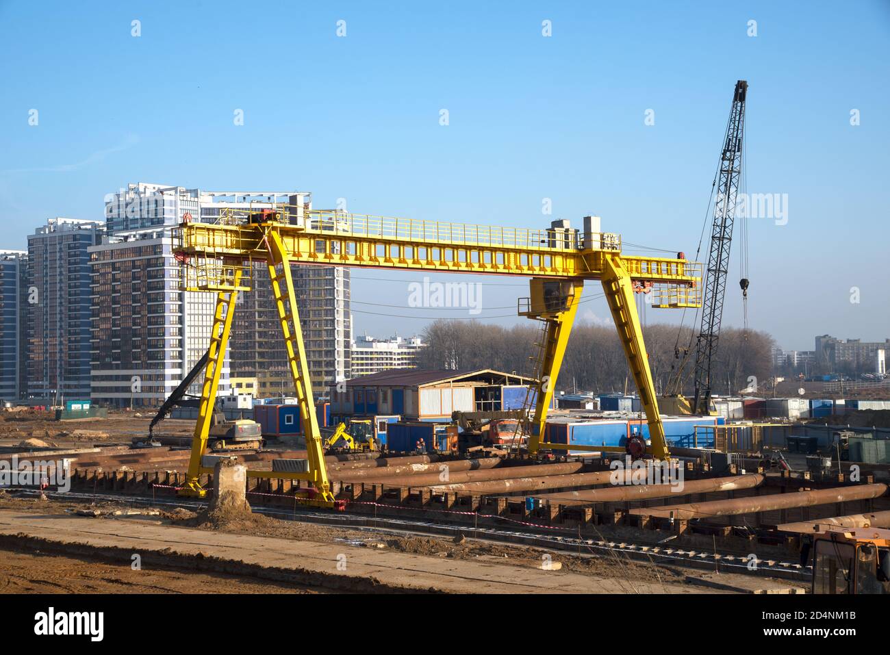 Gantry crane and auto crane working at construction site. Digging a pit ...