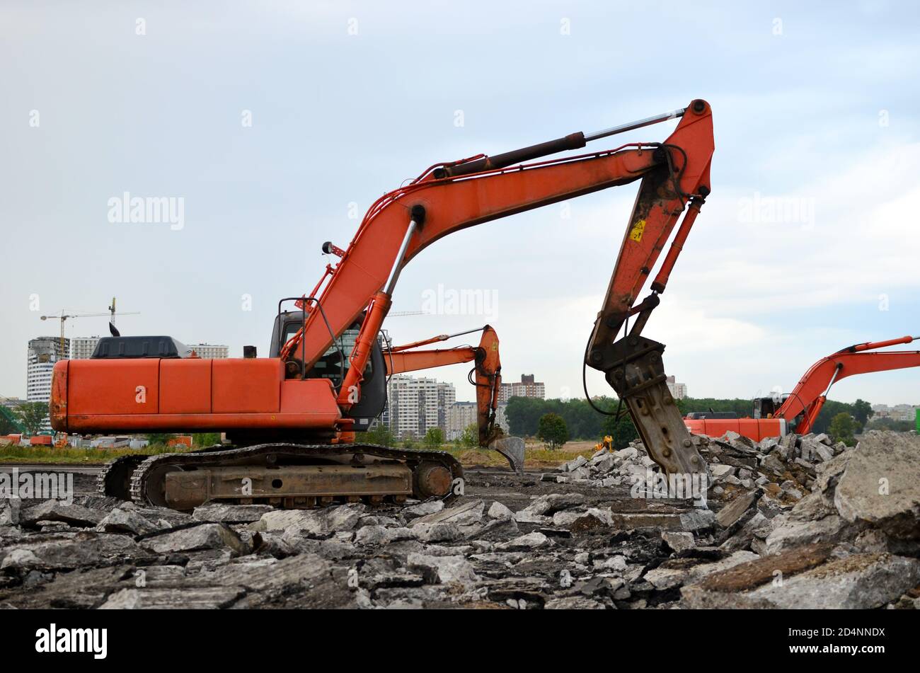 Large tracked excavator with hydraulic hammer breaks asphalt at a ...