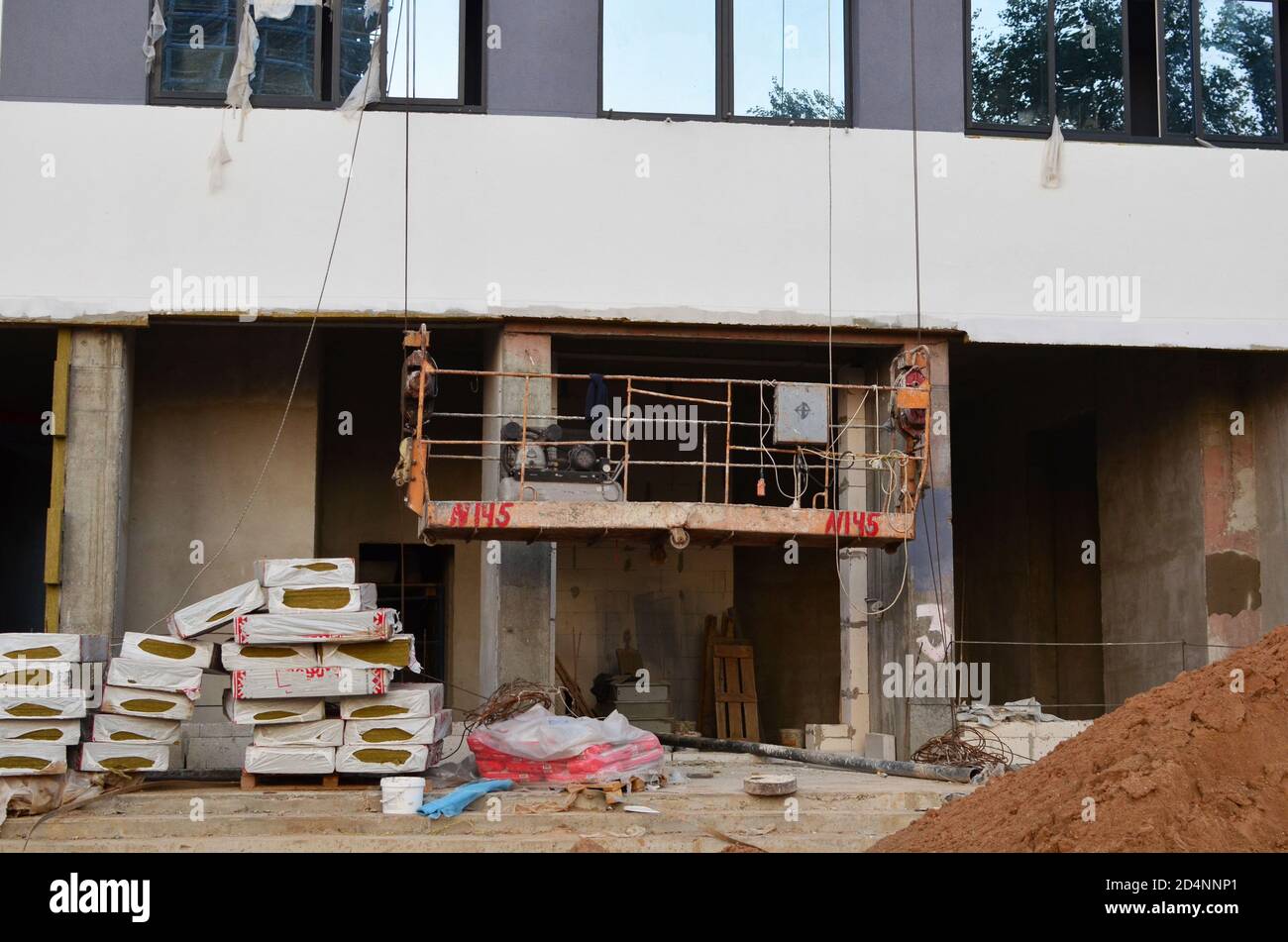 Suspended construction cradle on the background facade of the building ...