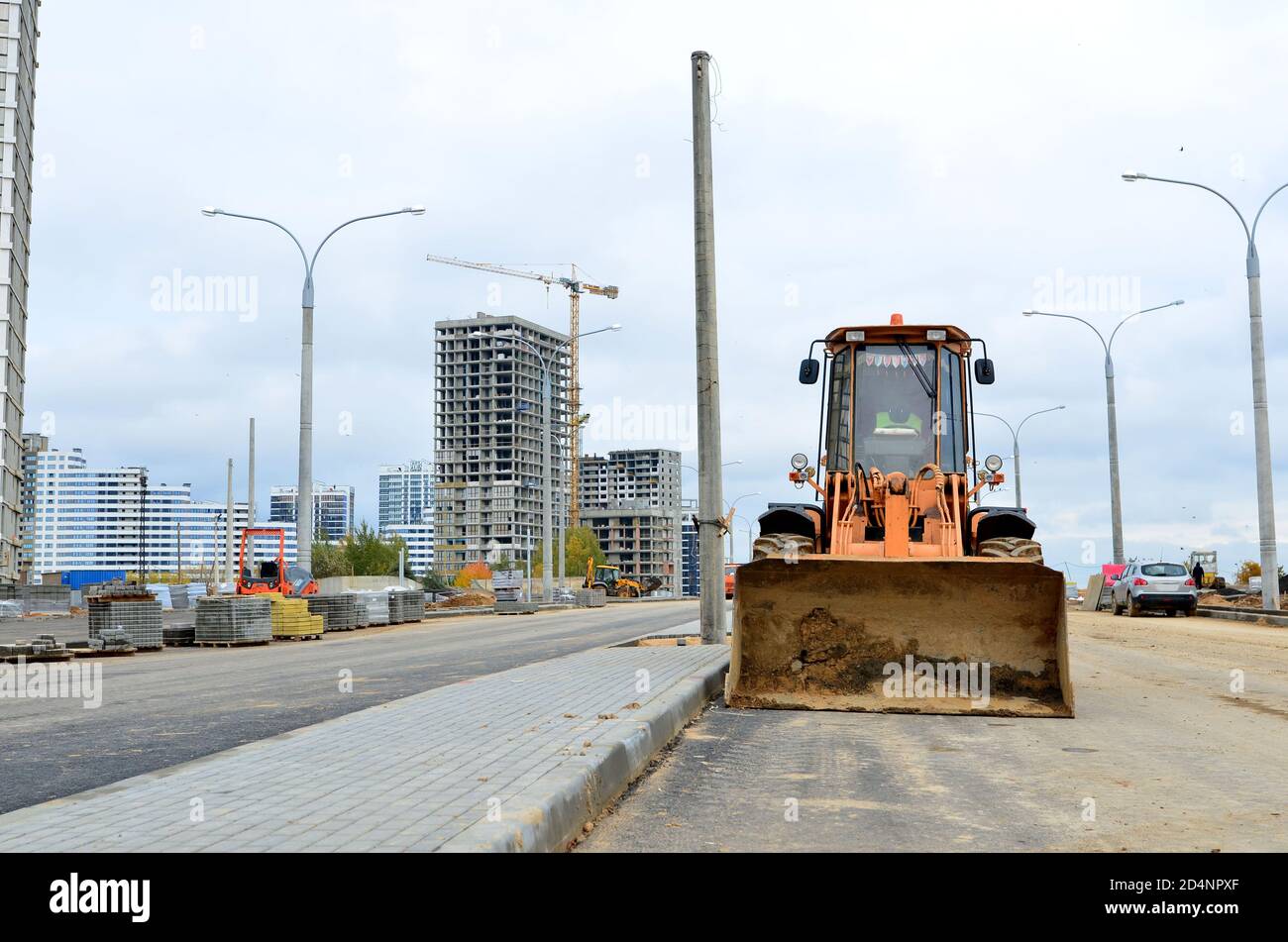 Wheel loader with a bucket on a street in the city during the ...