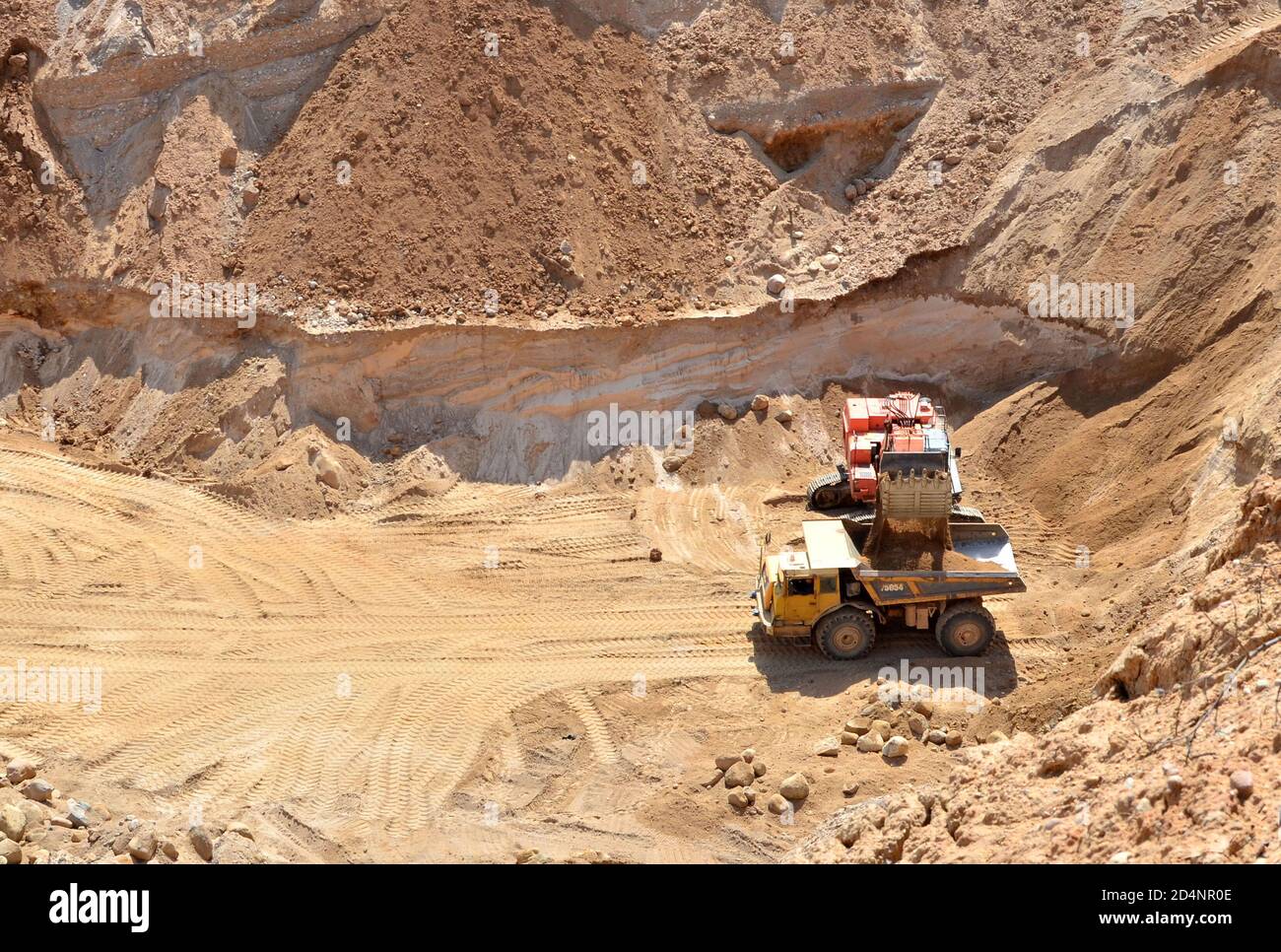 Excavator developing the sand on the opencast and loading it to the ...