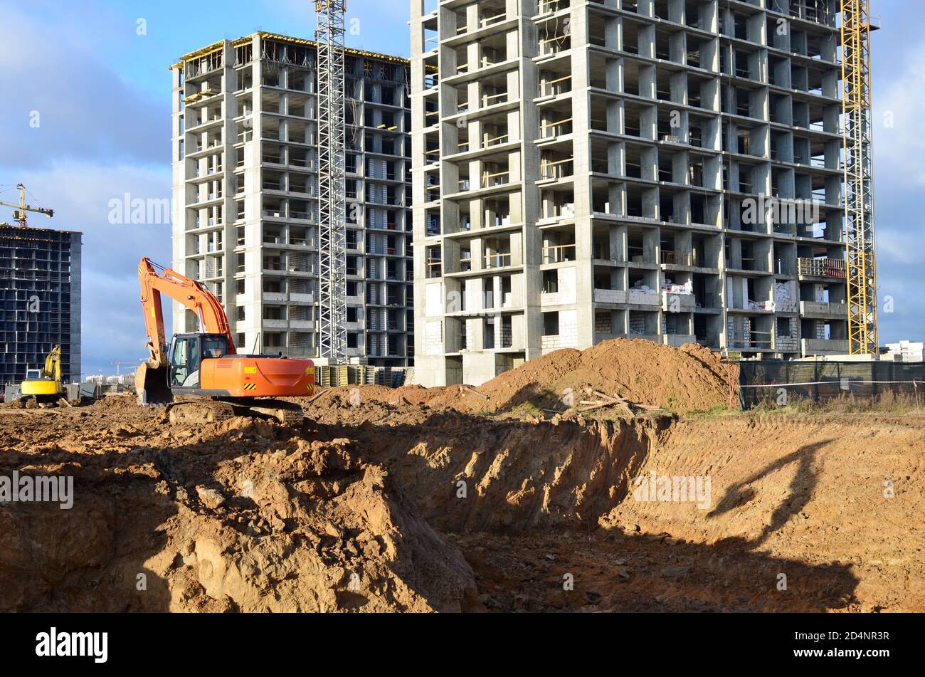 Excavator digs ground at a construction site for installing concrete ...