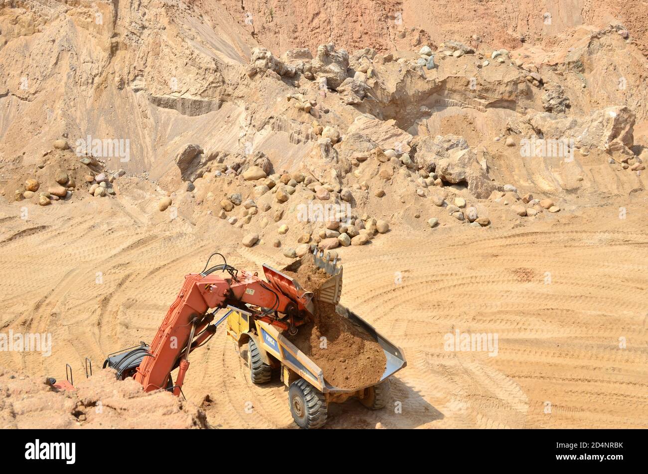 Excavator developing the sand on the opencast and loading it to the ...