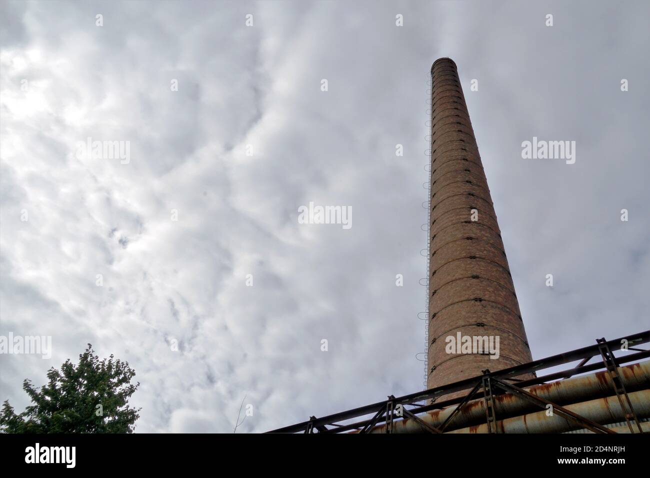 Tall brick chimney photographed at low angle in an old industrial zone ...