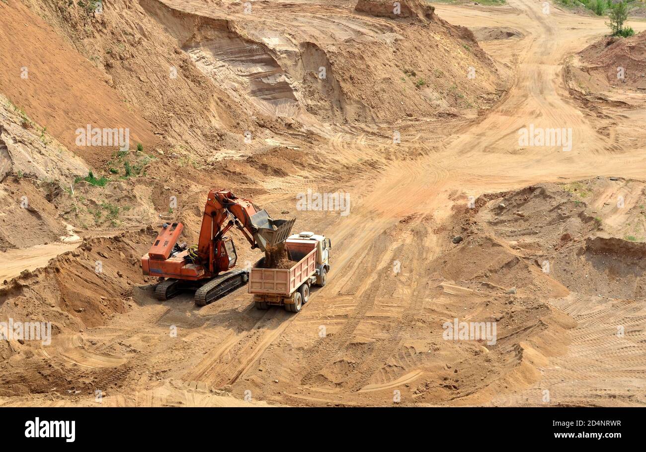 Excavator developing the sand on the opencast and loading it to the ...