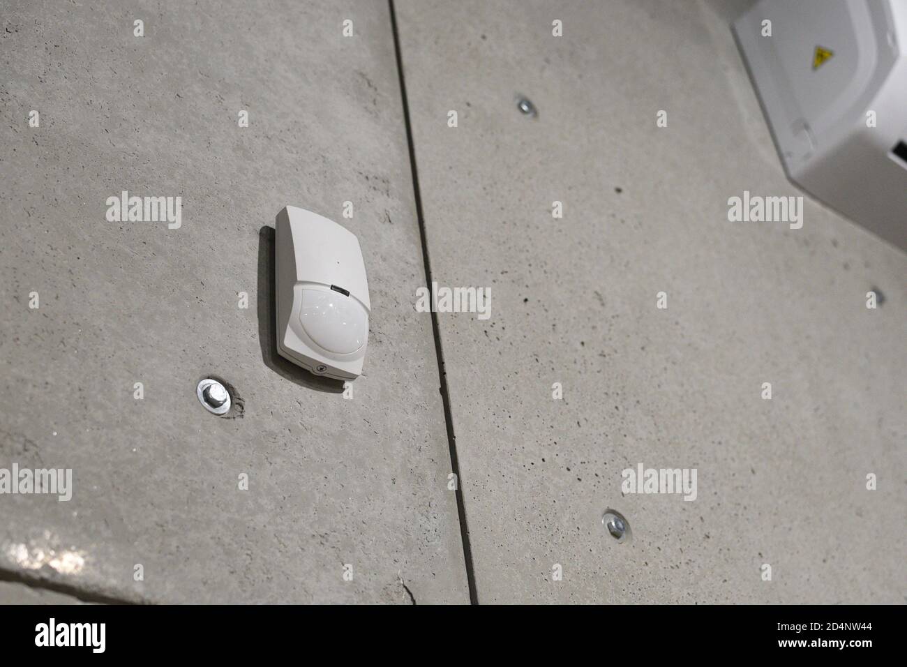 Wireless thief movement alarm on wall in room. PIR motion detector ...