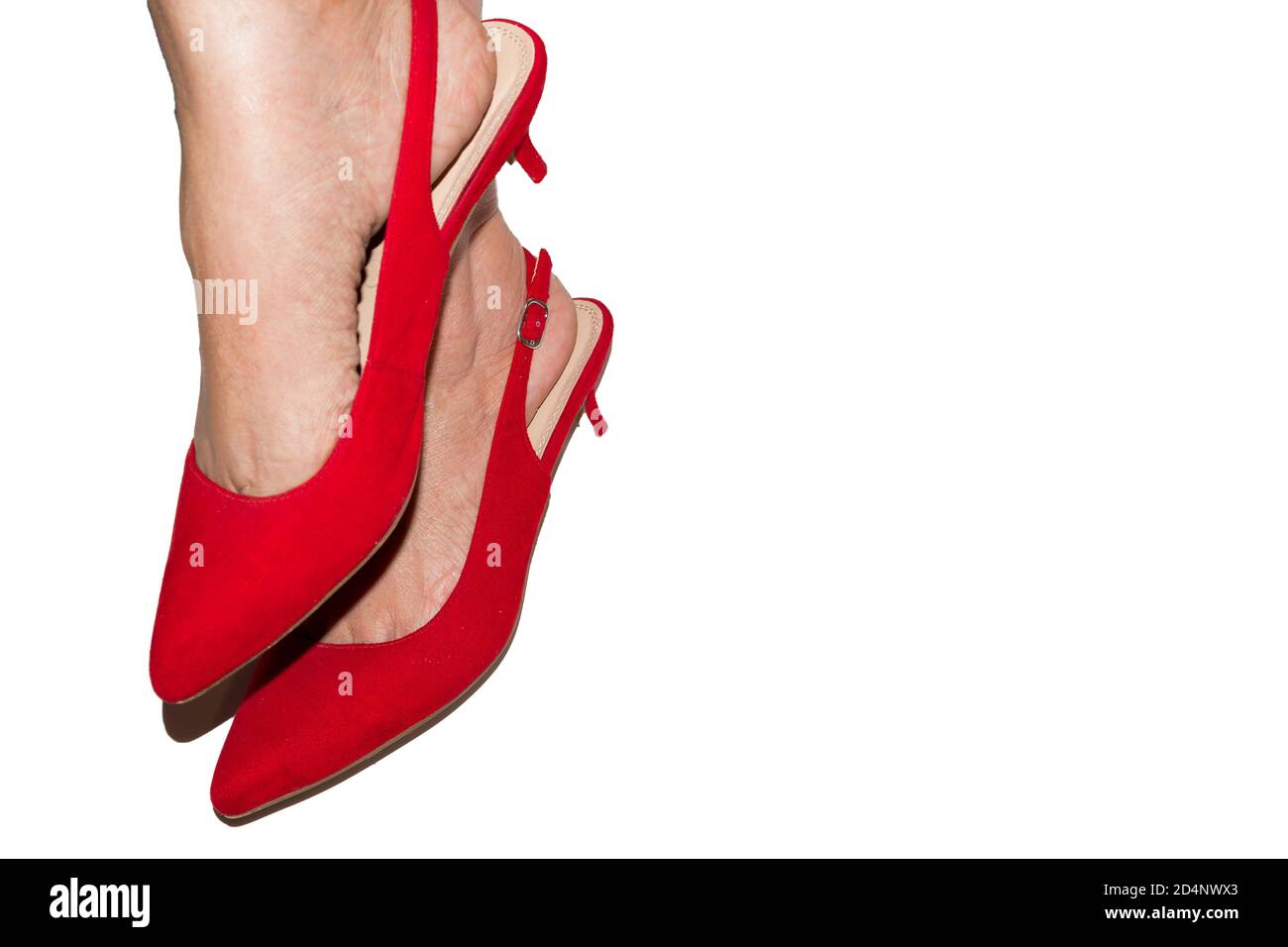 Closeup shot of female feet wearing bright red low heels on a white ...