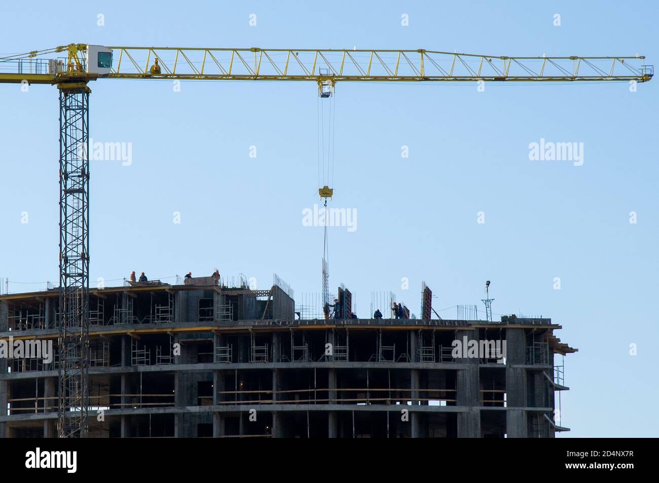 Hydraulic luffing jib tower cranes and workers being poured concrete ...