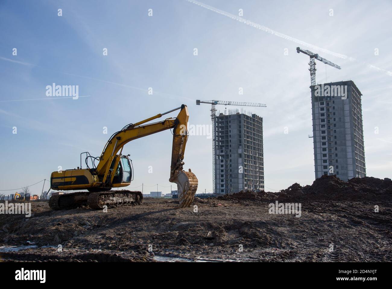 Excavator with bucket at large scale construction site on blue sky ...