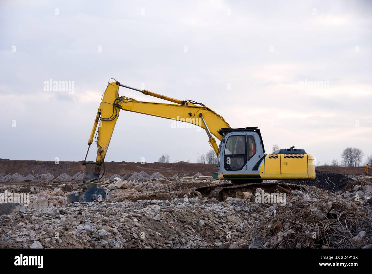 Excavator with crusher bucket for crushing concrete. Construction waste ...