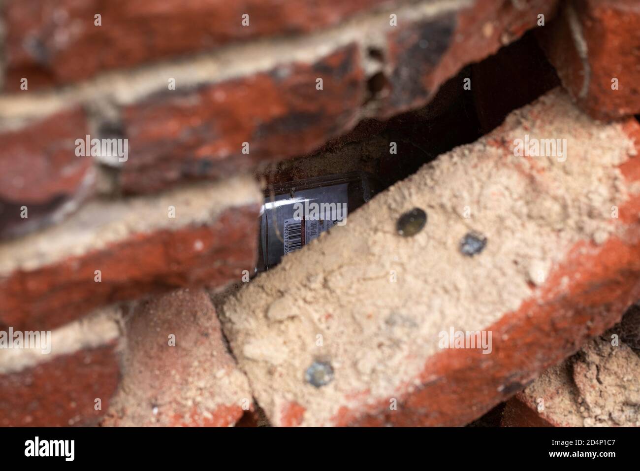 Empty vodka bottles hidden in a breach in old medieval brick wall ...