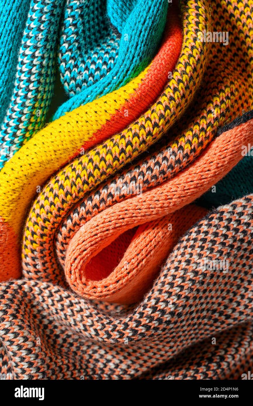 Twisted folds of colorful knitted fabrics of winter clothes with ...