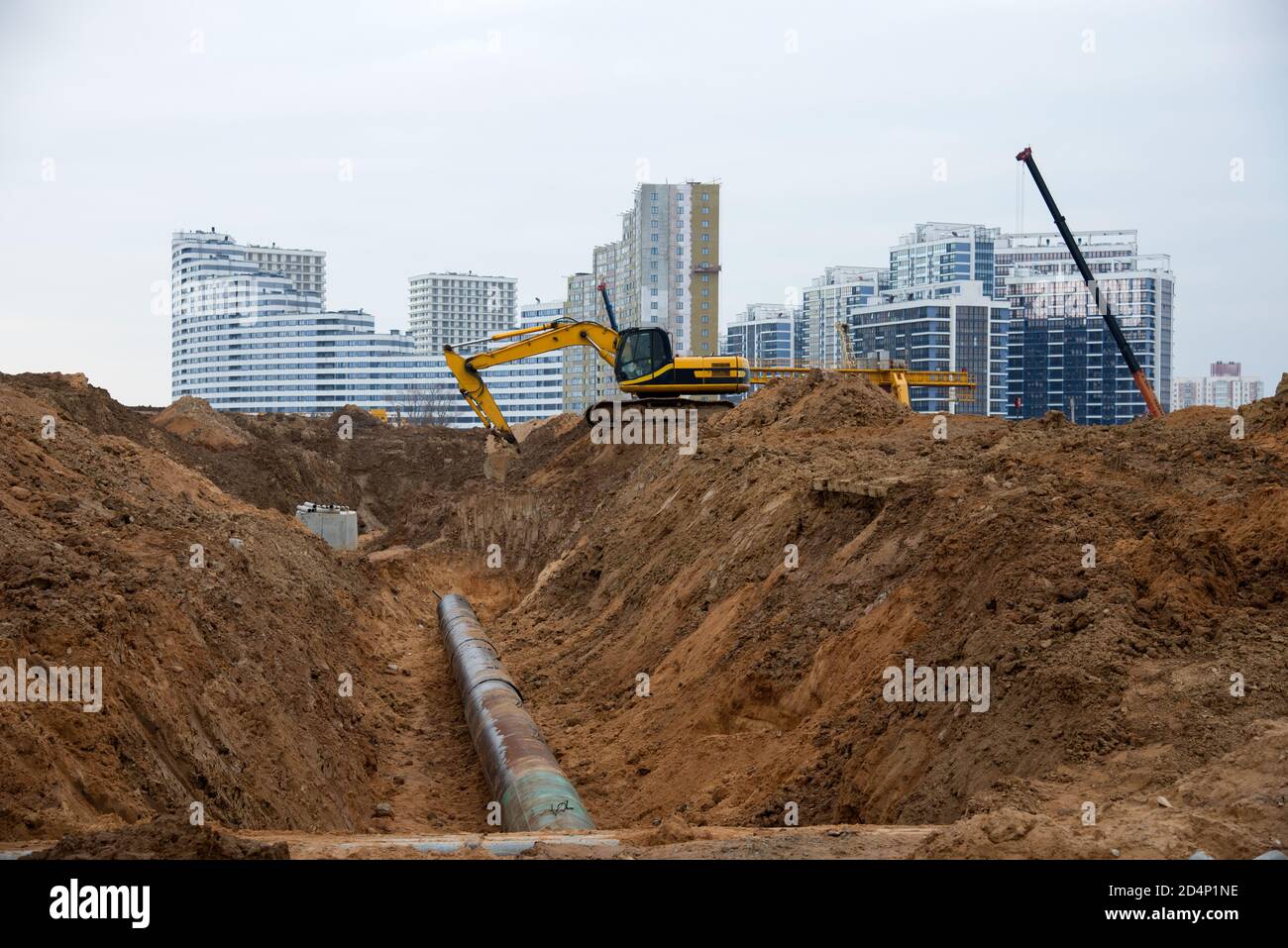 Excavator at construction site during laying sewer and main ...