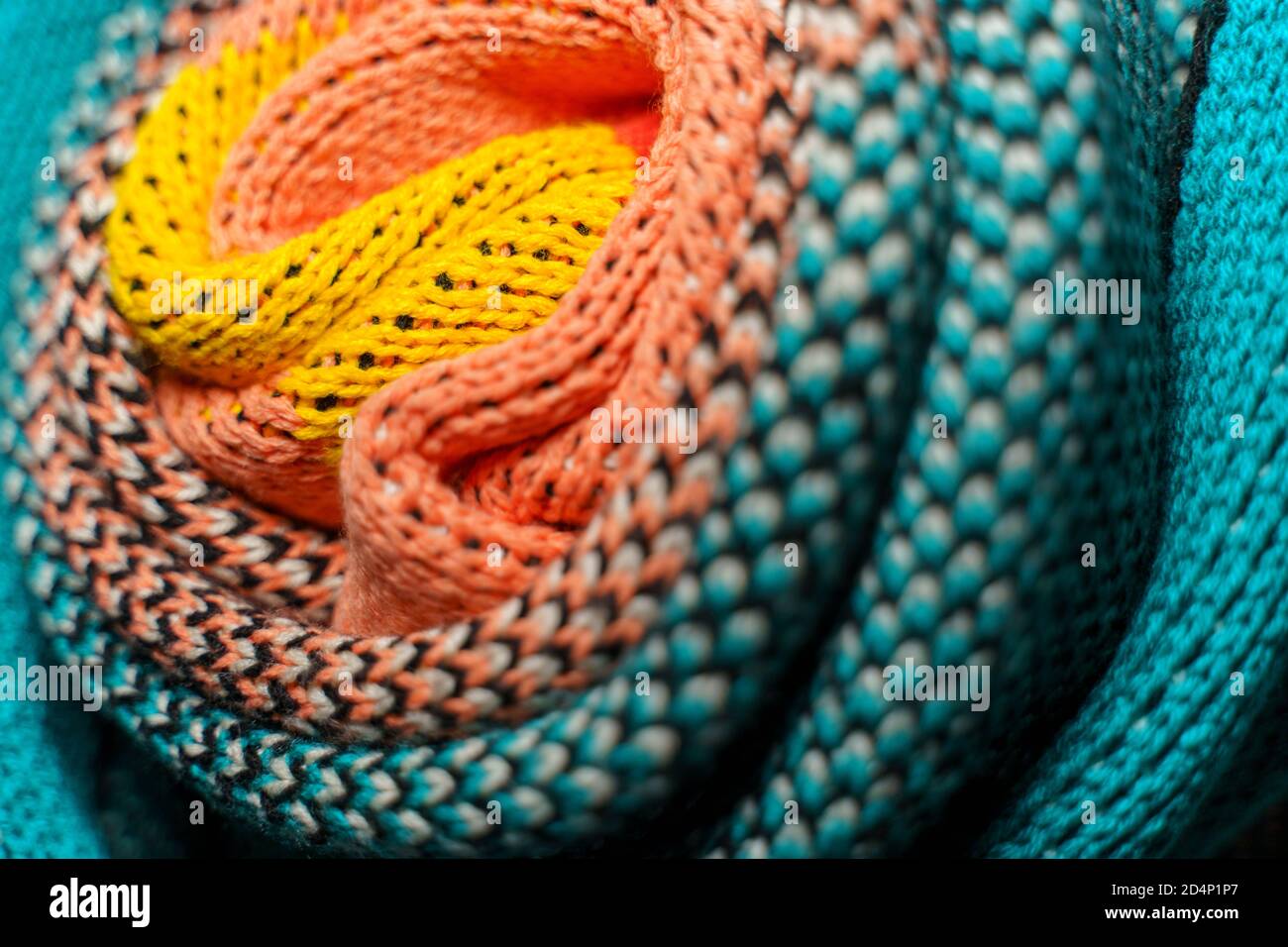 Twisted folds of colorful knitted fabrics of winter clothes with ...