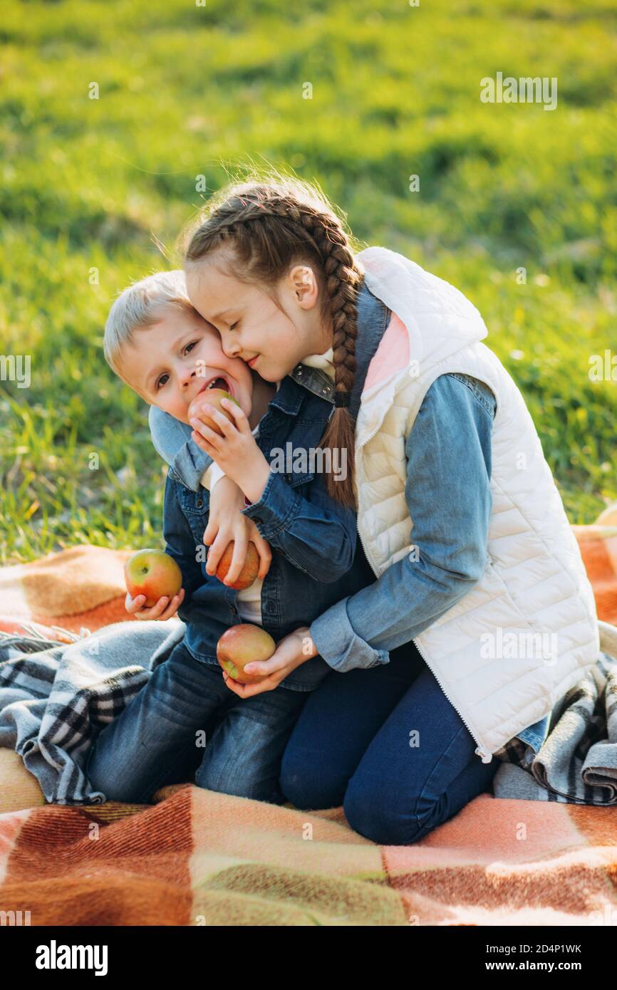 Children eat apples on the green grass Stock Photo - Alamy