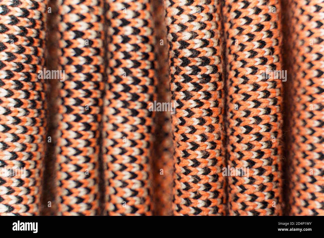 Folded synthetic knitted fabric with pattern elements of red, black and ...