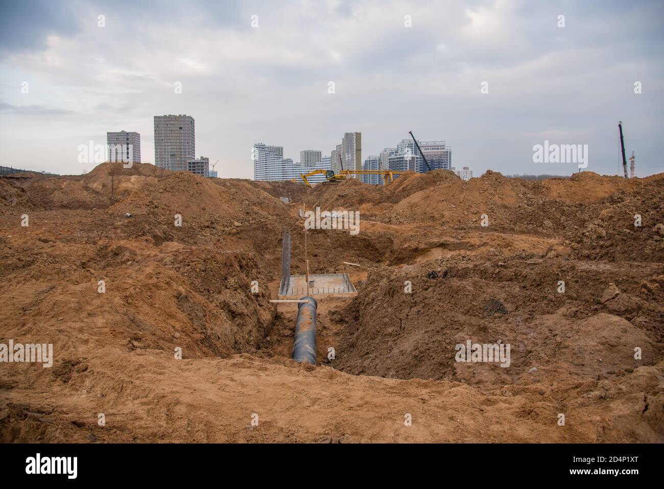 Excavator at construction site during laying sewer and main ...