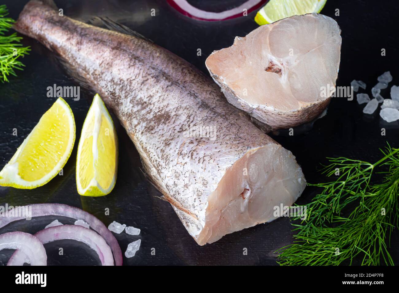 Fresh frozen hake carcass. Fish fillet with culinary ingredients, herbs ...