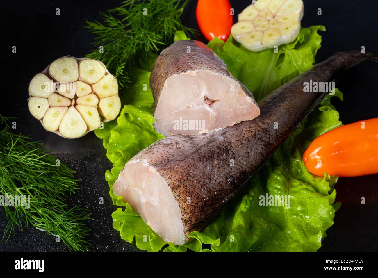 Fresh frozen hake carcass. Fish fillet with culinary ingredients, herbs ...