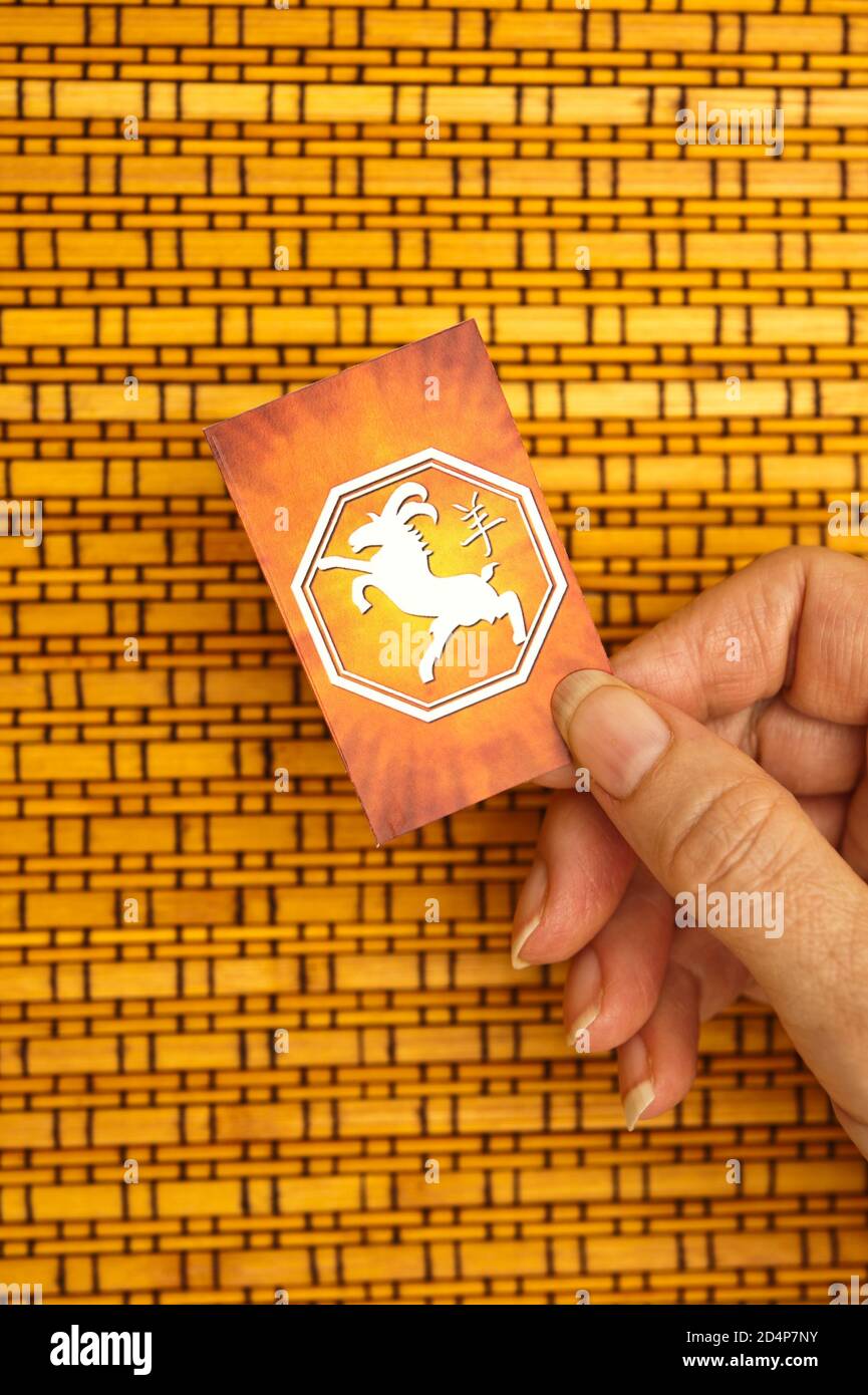hand holding a card of the Chinese horoscope sign Goat Stock Photo - Alamy
