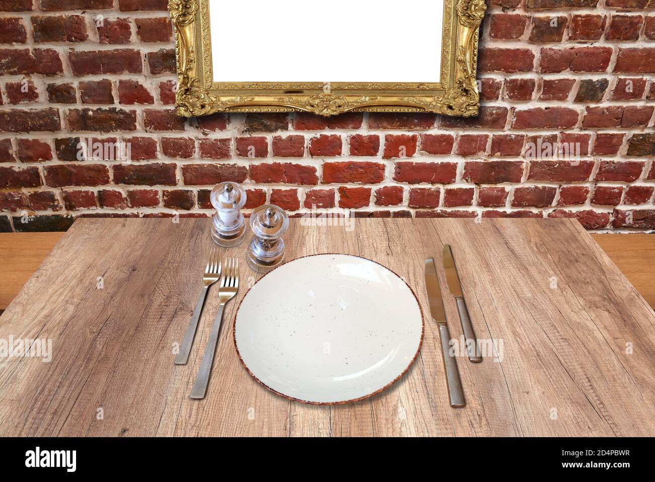 Rustic wooden table with a set of silverware and empty plate against ...