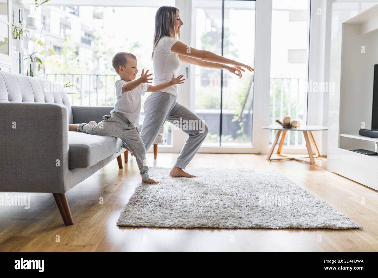 Mom with her young son working out in the living room Stock Photo - Alamy