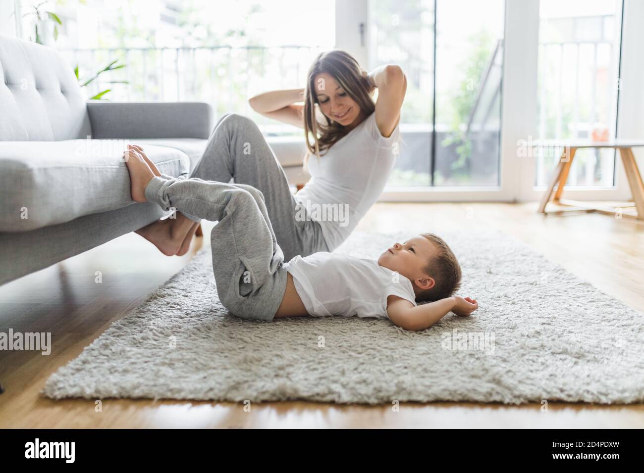 Mom with her young son working out in the living room Stock Photo - Alamy