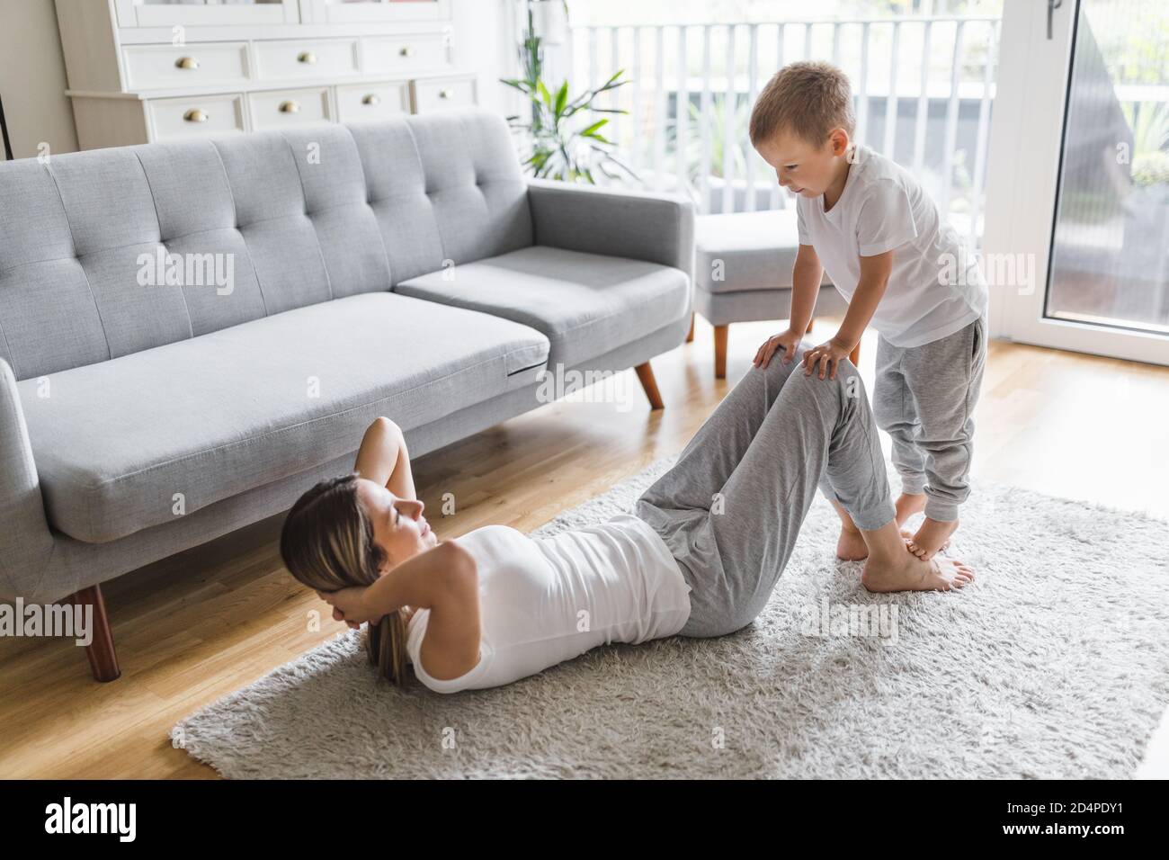 Mom with her young son working out in the living room Stock Photo - Alamy