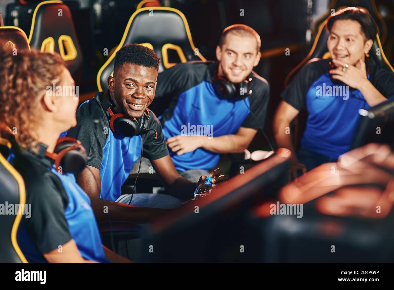 Happy professional multiracial cybersport team talking and discussing ...