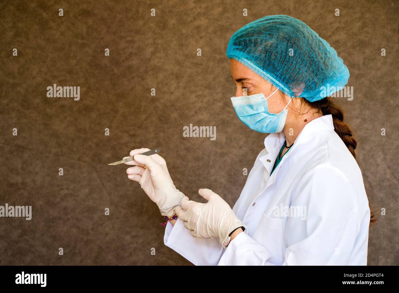 Doctors portrait with mask, glove and uniform and surgery blade in hand ...