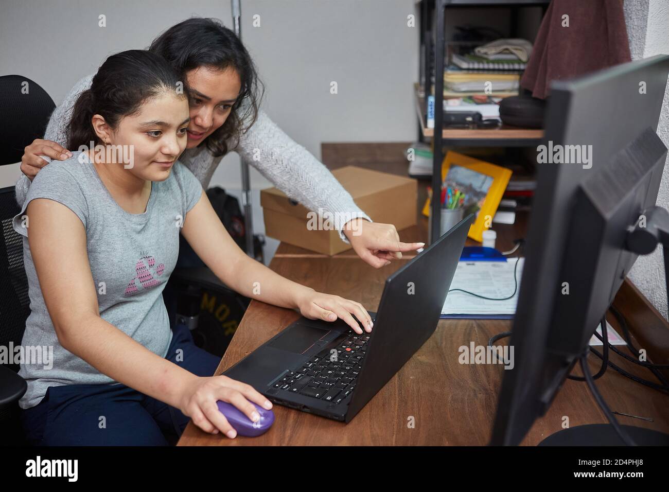 Mother helping her daughter to use the computer Stock Photo - Alamy