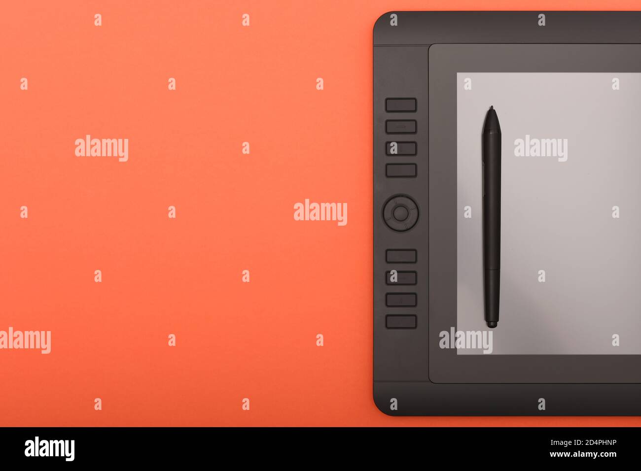 Graphic monitor stylus on orange color table. Black tablet computer ...