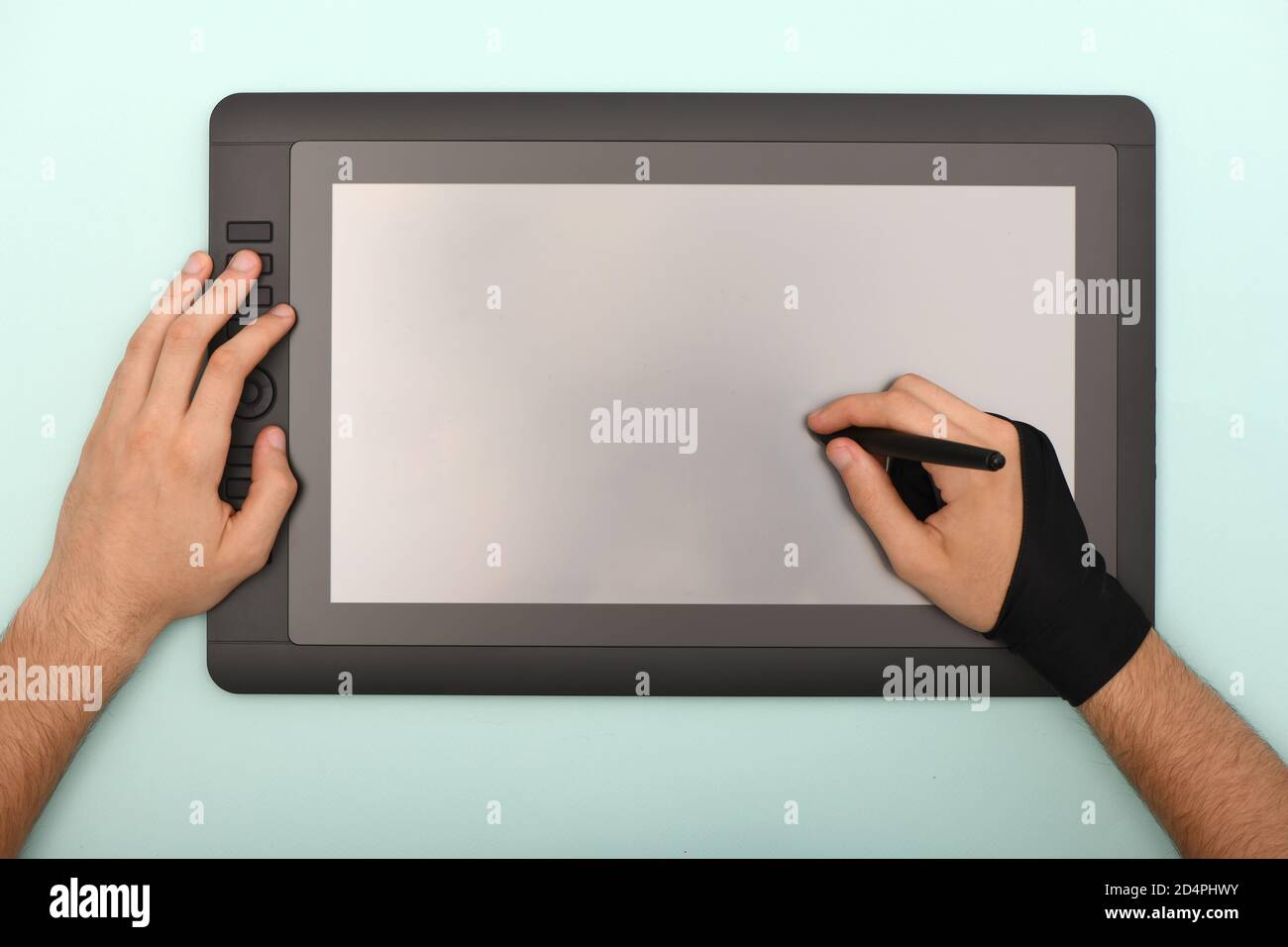 Man hands works on graphic monitor on lime color table. Black tablet ...