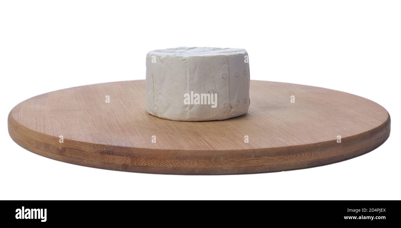 Camembert cheese with white mold on a round board isolated on a white ...