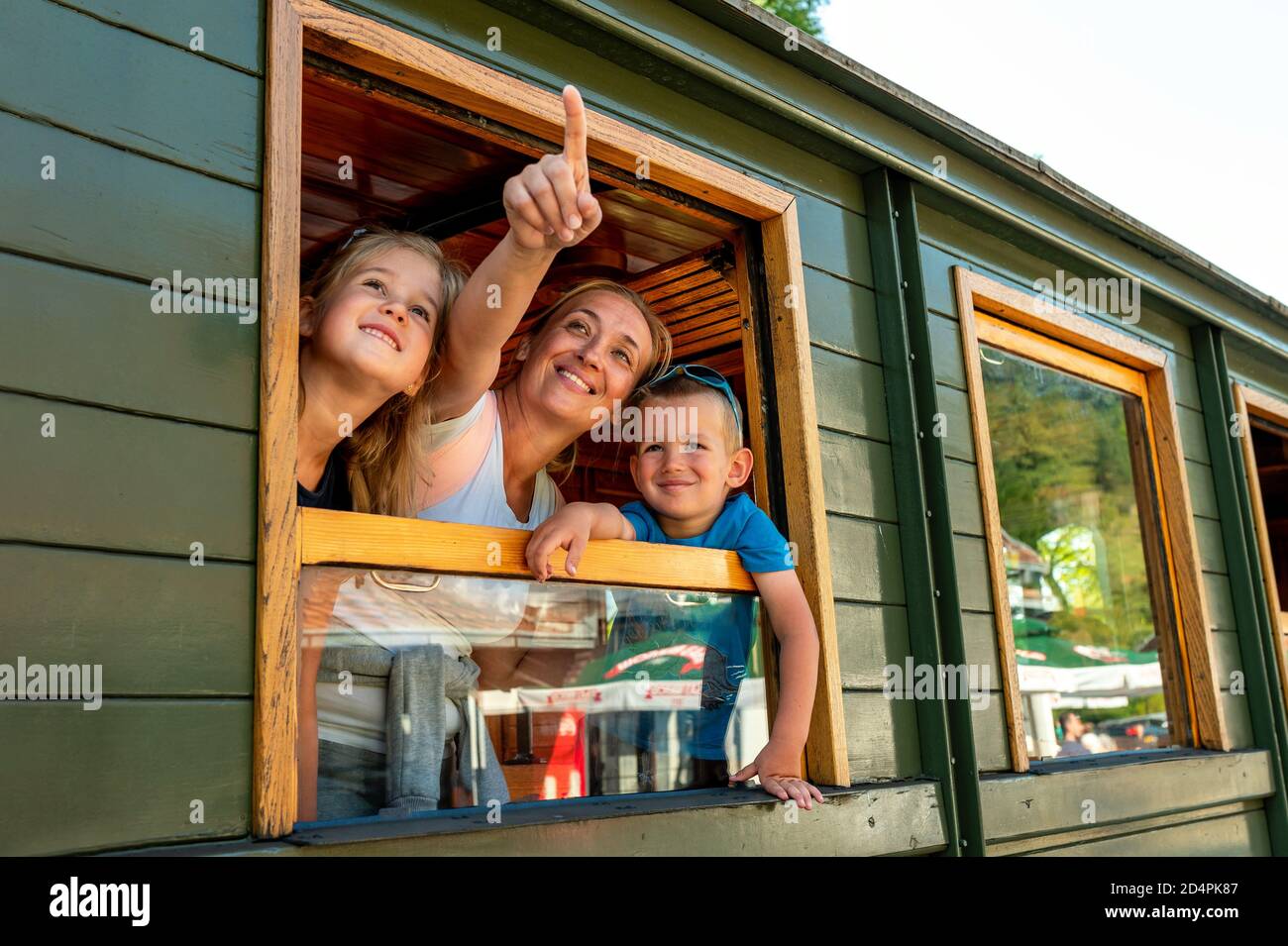 Mother and her children looking out the window of a train Stock Photo ...