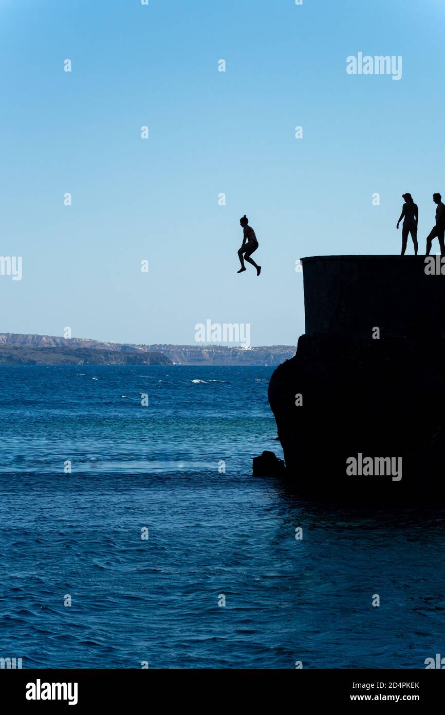 Group of friends jumping into mediterranean sea from rock cliff Stock ...