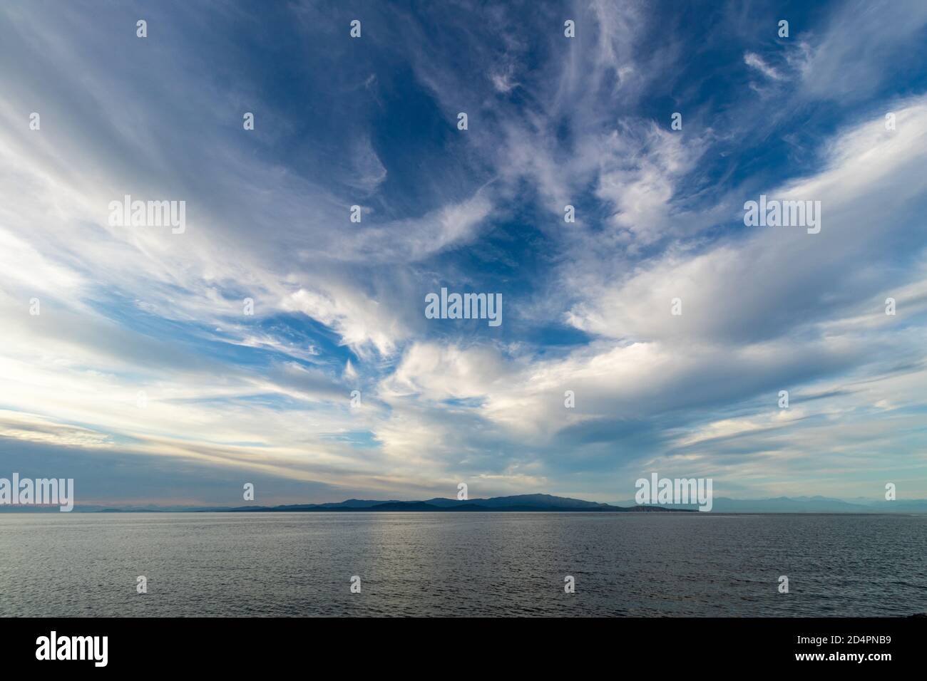 In the distance a formation of clouds over water and a small island ...