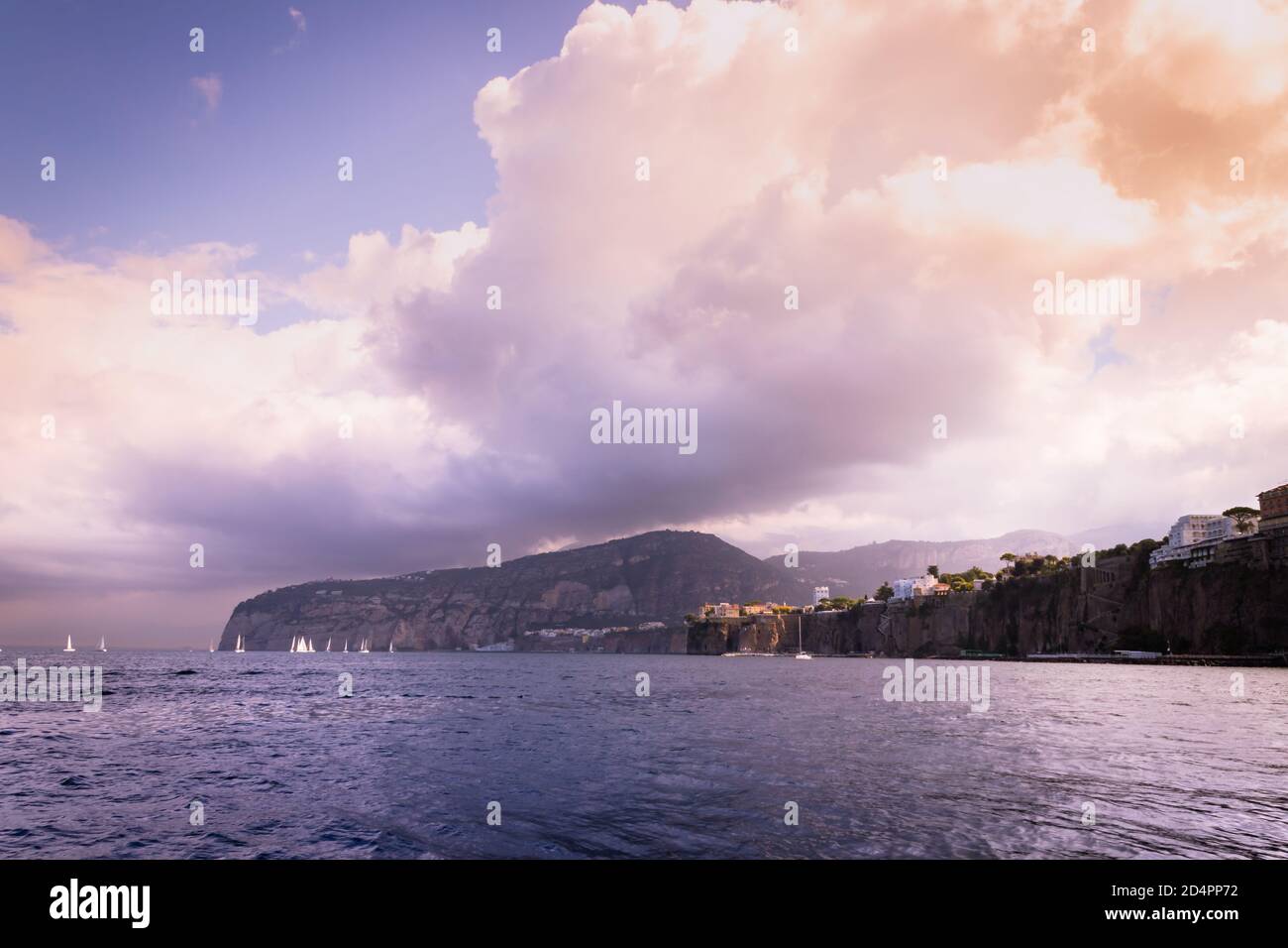 Landscape view of the steep cliffs with houses on and boats in the the ...