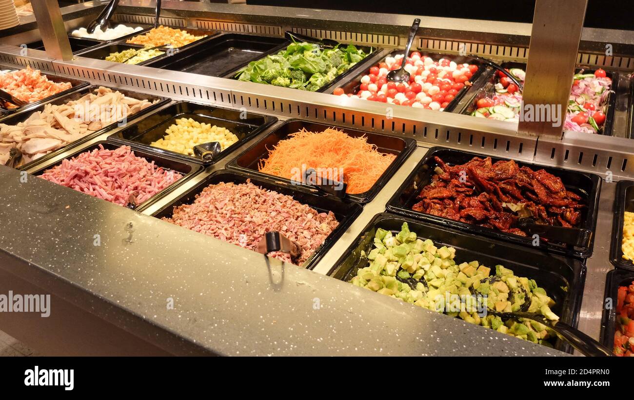 Salad bar with salad, tomatoes, shrimps, avocado, pasta, eggs, meat ...