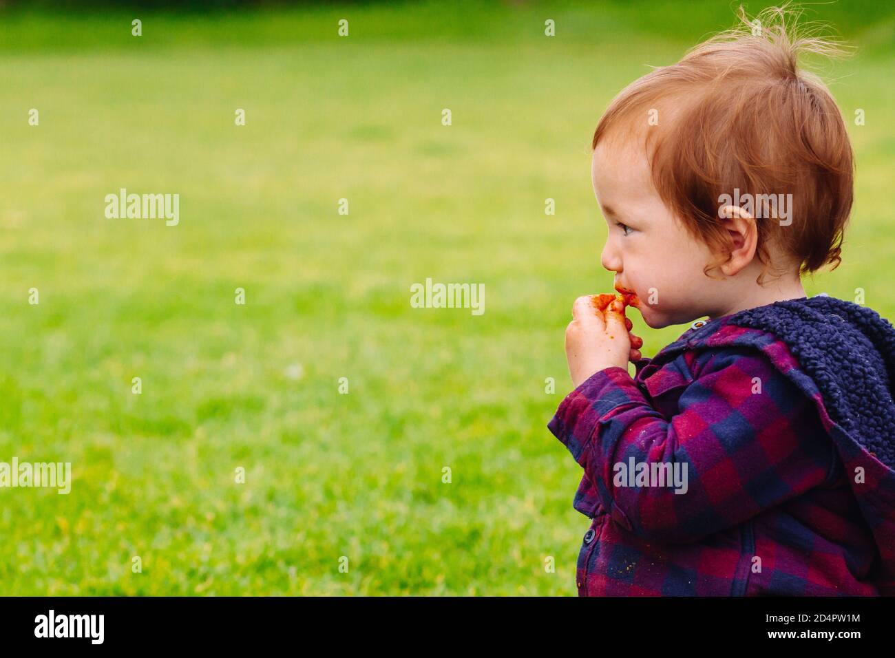 Toddler seen in profile enjoying some food Stock Photo - Alamy