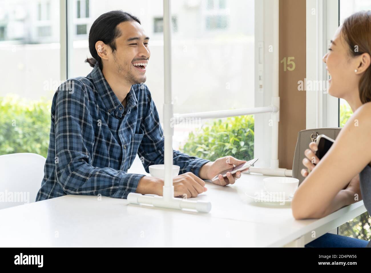 Asian young couple eating out together at new normal social distance ...