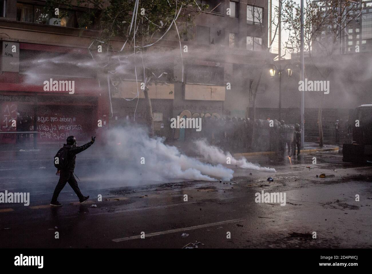 A protester walks amidst tear gas smoke during the demonstration ...