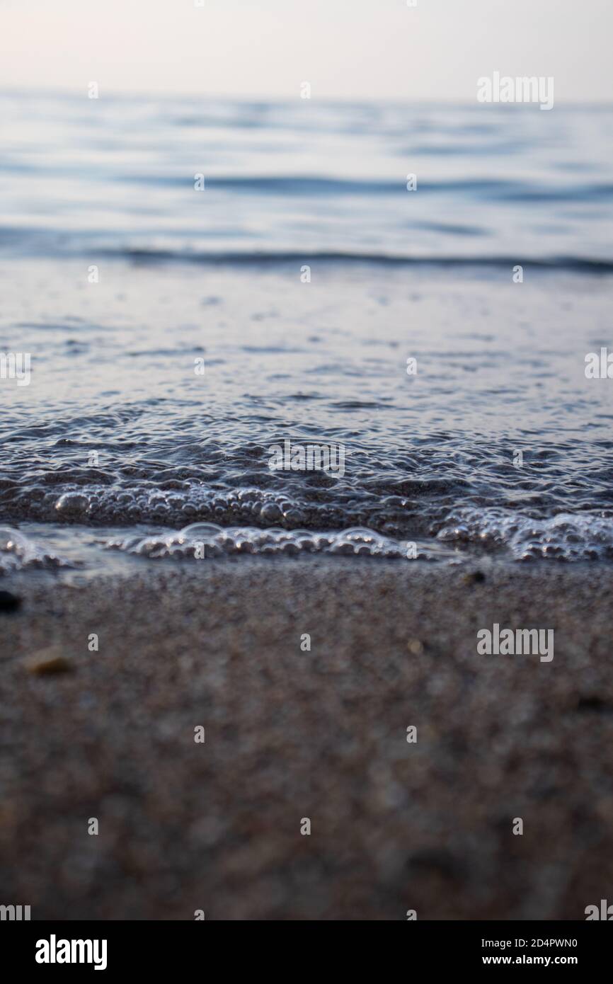 Close-up of waves and bubbles seaside, clear blue water Stock Photo - Alamy