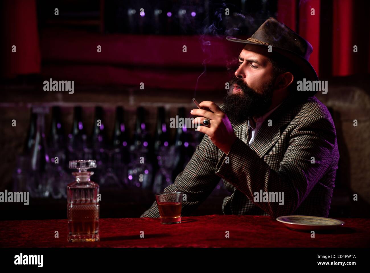 Bearded hipster man smoking cigarettes with glass of wiskey Stock Photo ...