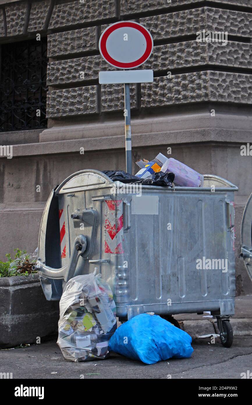 Full open metal garbage container on urban city street Stock Photo - Alamy
