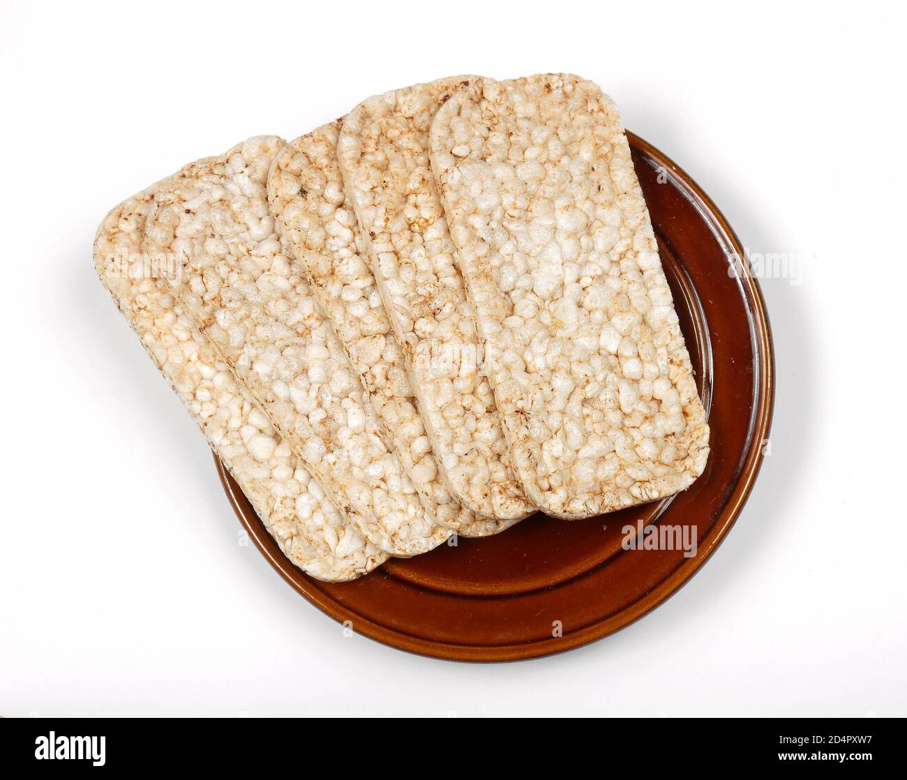 Pile of rice crackers on plate on white background Stock Photo - Alamy