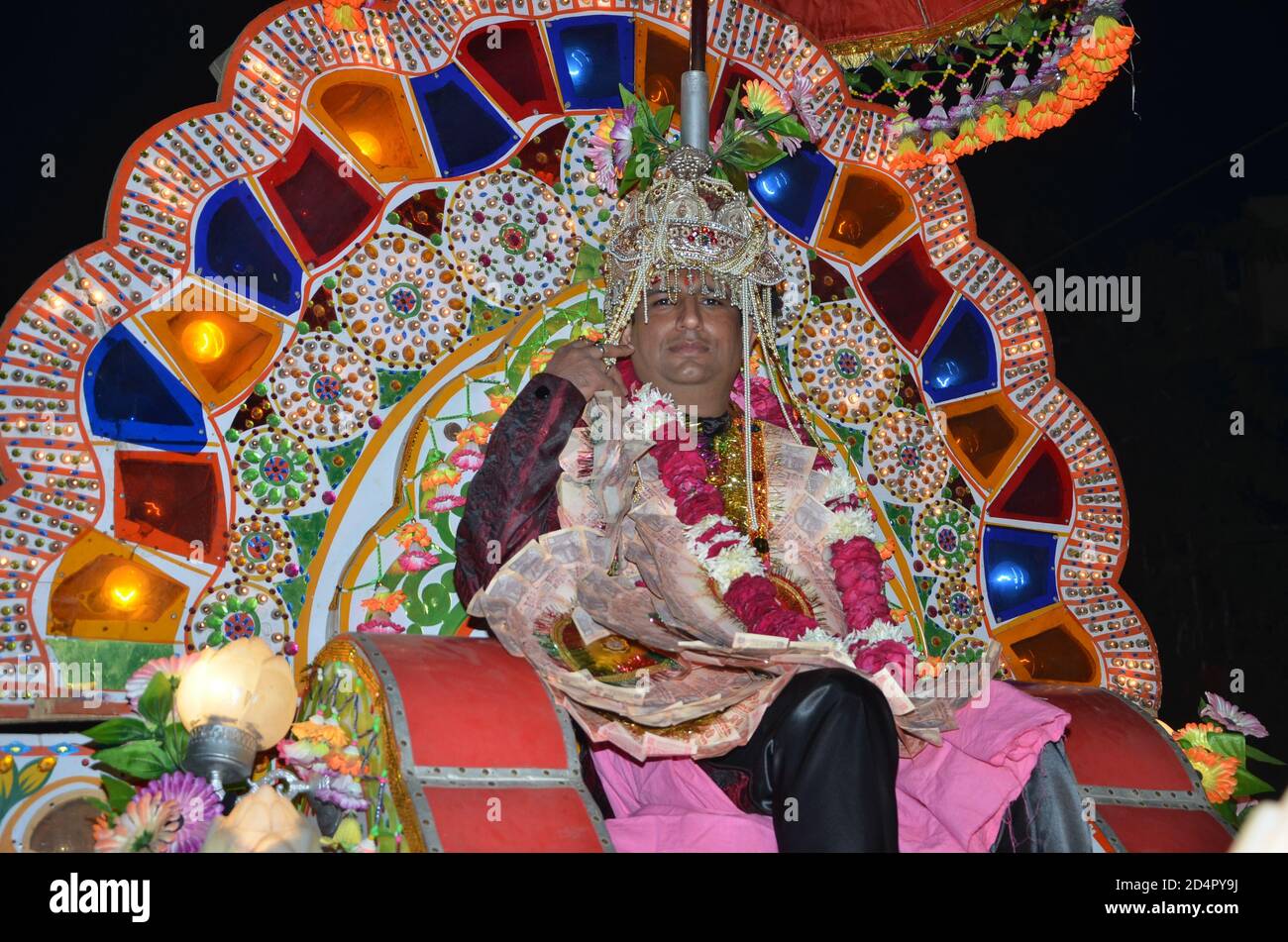 Smart Indian bridegroom sitting on a Wedding Baggi with colorful lights ...