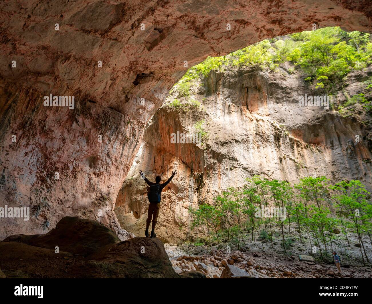 Walker stretching his arms in the air, cave Cueva de La Ermita, canyon ...