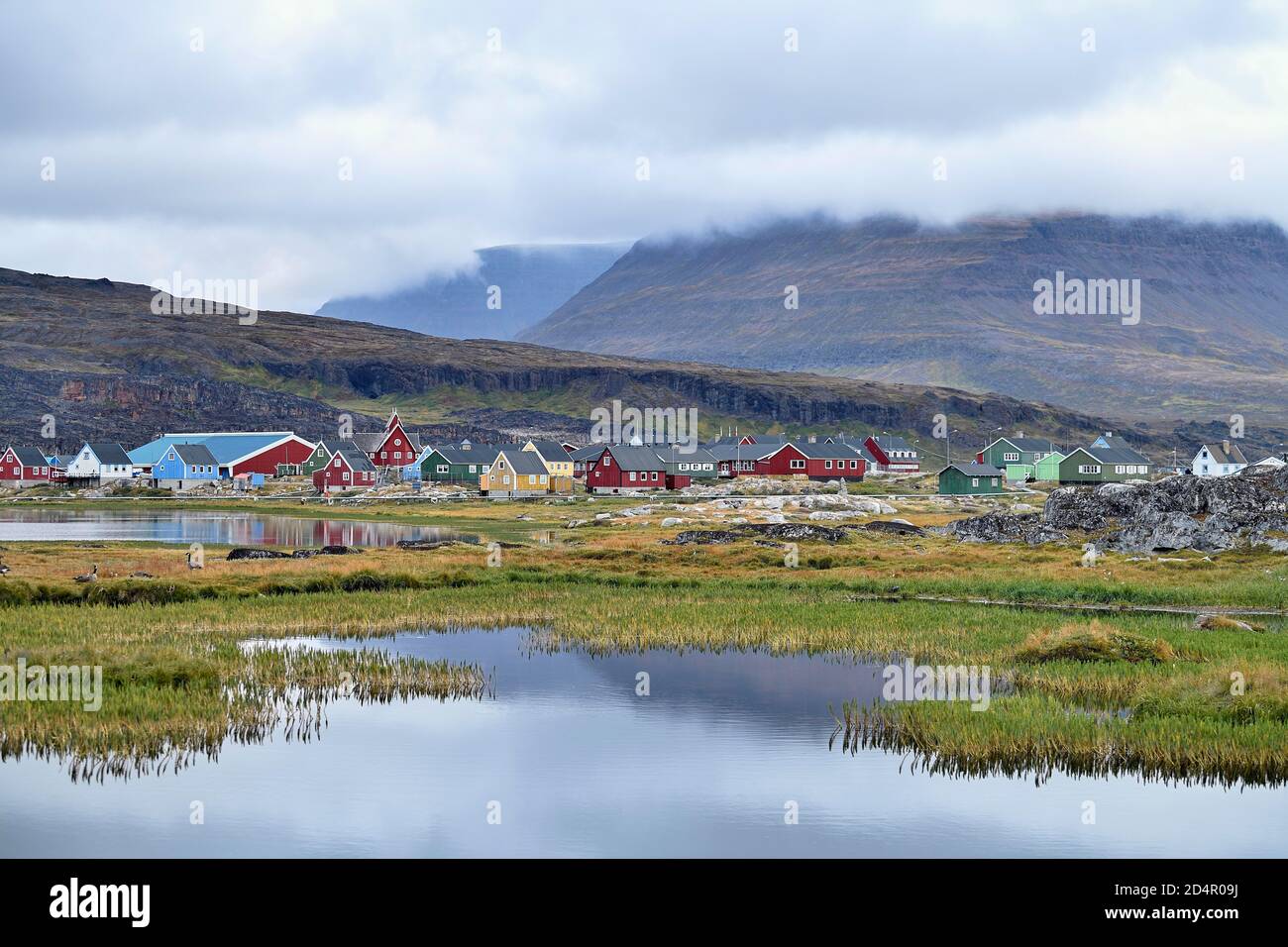 Village view with typical colourful painted houses, in front small pond ...