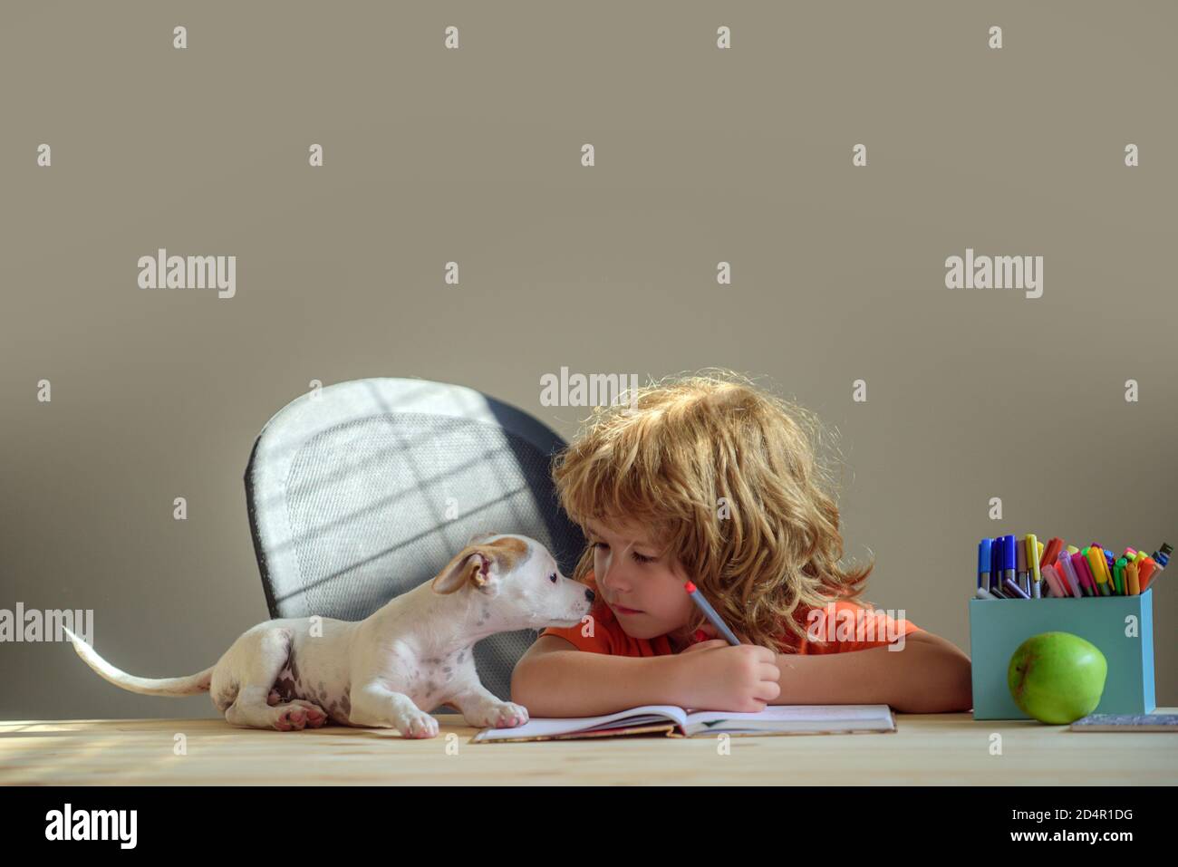 Cute child learning at home. Puppy dog helping kid with education ...